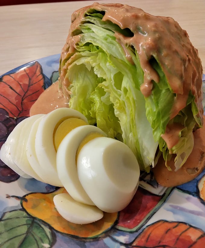 A wedge salad that stands tall and proud, draped in Russian dressing like it's wearing a designer gown. The sliced eggs add a protein power boost.