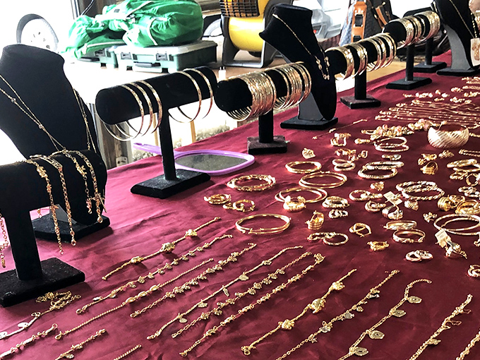 Gold bangles and delicate chains spread across burgundy velvet&mdash;where someone's perfect anniversary gift waits to be discovered for a fraction of retail.