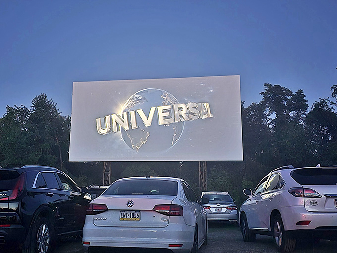 The Universal globe spins to life as darkness falls. That familiar logo hits differently when it's towering above a field of cars.