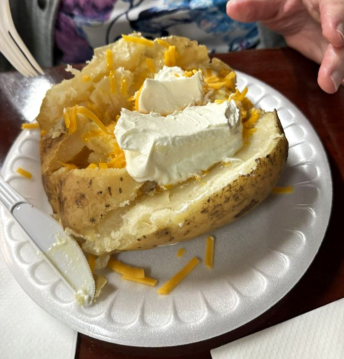 A loaded baked potato that's practically a meal unto itself - cheese melting into every crevice like it's found its forever home.