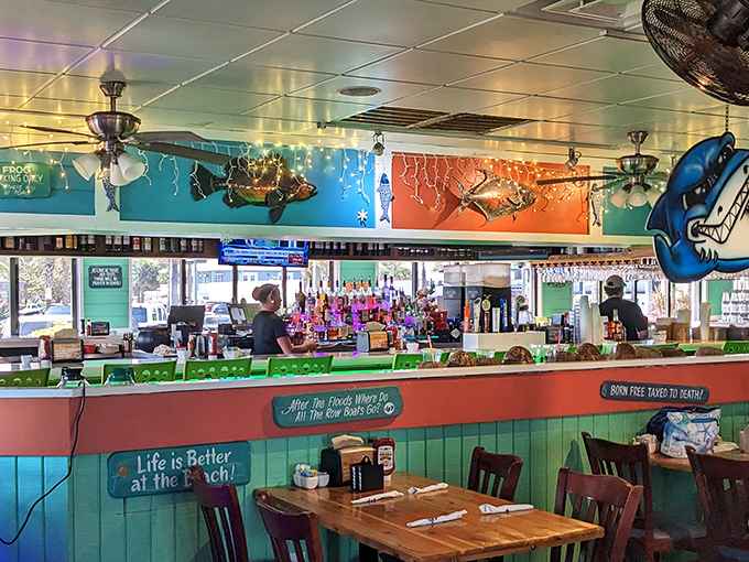 The bar area pops with coastal colors and quirky fish art, creating the perfect backdrop for stories that get better with each tropical libation.