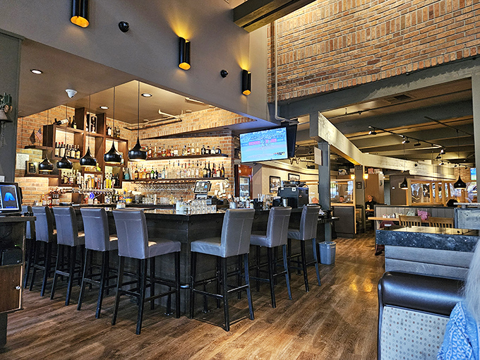 A bar area that says "stay awhile" with exposed brick walls and an impressive selection of spirits. The kind of place where strangers become friends.