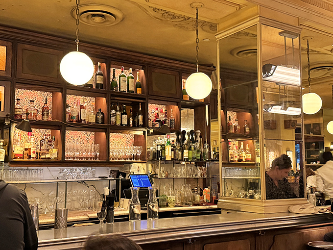 A bar that Hemingway would approve of, where bottles gleam like jewels. The globe lights cast the kind of glow that makes everyone look mysterious and interesting.