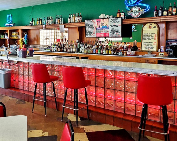The bar's illuminated glass blocks glow like a beacon for thirsty patrons. Those red stools have supported generations of Indianapolis residents.