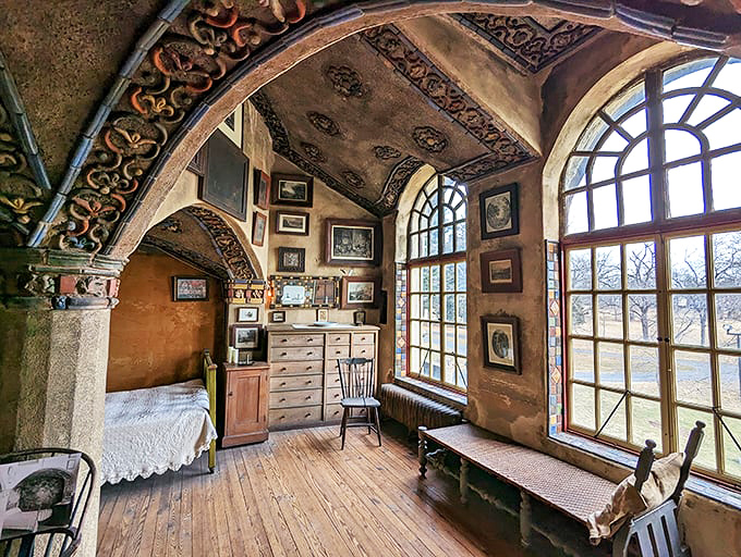 This bedroom alcove proves even concrete can feel cozy when bathed in golden light through handcrafted windows.
