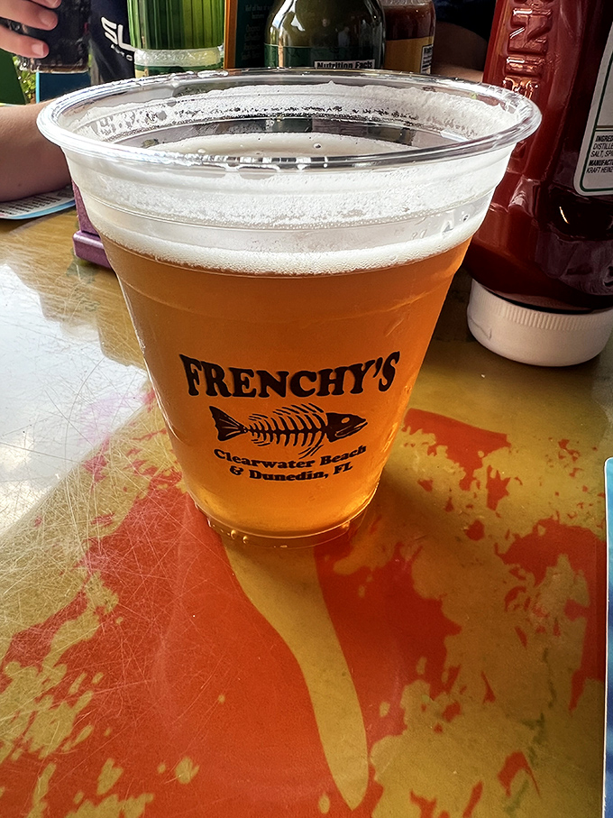 A cold beer in a Frenchy's cup—because sometimes the perfect beverage pairing isn't complicated, it's just refreshingly right.