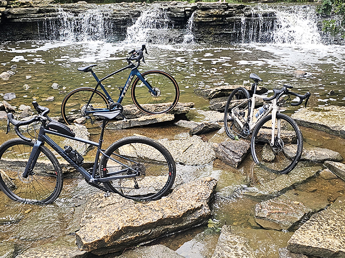 Cyclists pause to document their conquest of wilderness and waterfall. The ultimate "I earned this view" moment that no gym selfie can match.