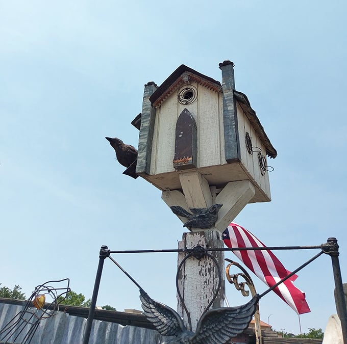 Not just a birdhouse but a whimsical folk art statement piece that's survived countless seasons perched atop its post, American flag included.