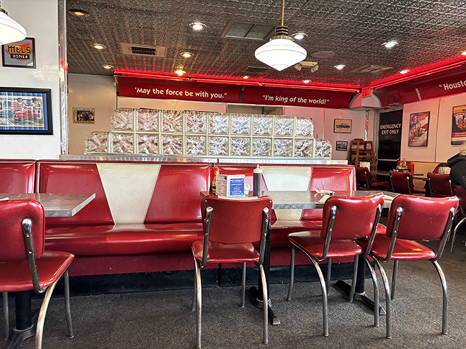 Movie quotes dance above cherry-red booths where countless birthdays, first dates, and "just because" meals have unfolded. The diner's soul lives in these seats.