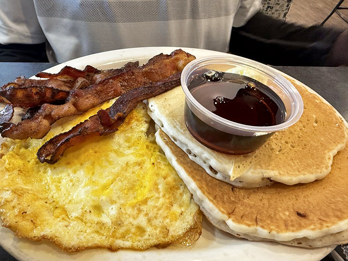 The breakfast platter that answers "Why choose?" with "You don't have to"&mdash;eggs, bacon, and pancakes in perfect harmony.