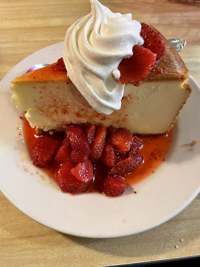 Cheesecake topped with strawberries and whipped cream—the kind of dessert that makes you reconsider your life choices in the best way.