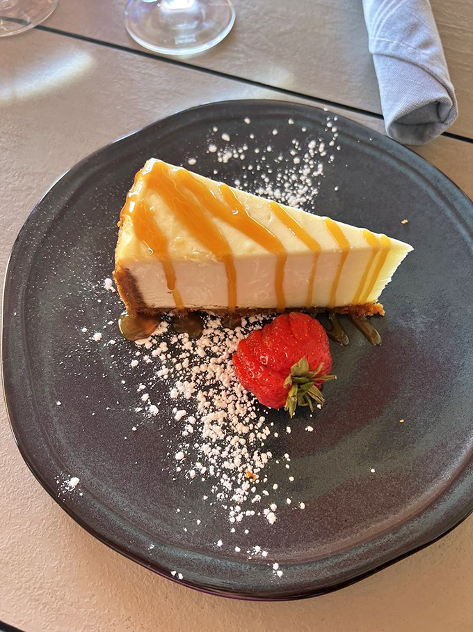 Cheesecake drizzled with caramel and paired with a strawberry &ndash; dessert that makes you consider ordering a second slice before finishing the first.