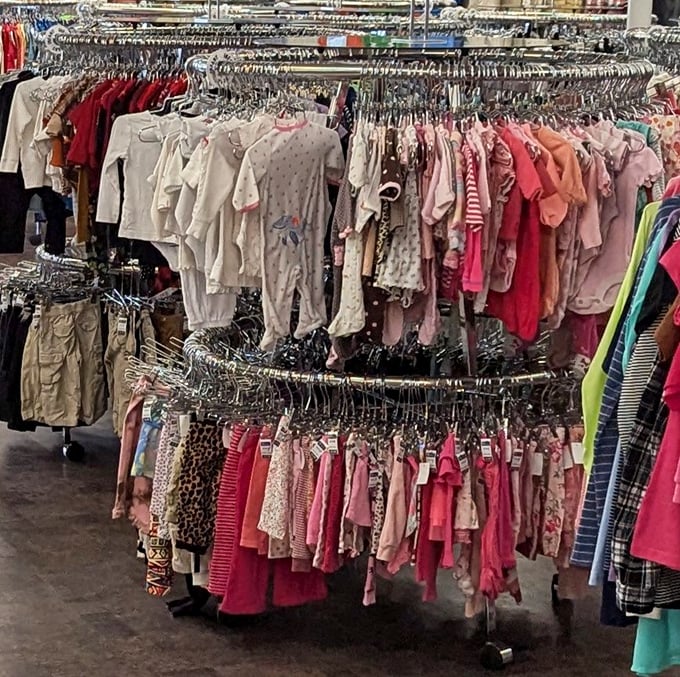 This clothing carousel spins with options in every color imaginable, because why settle for boring when thrift stores offer rainbow variety?