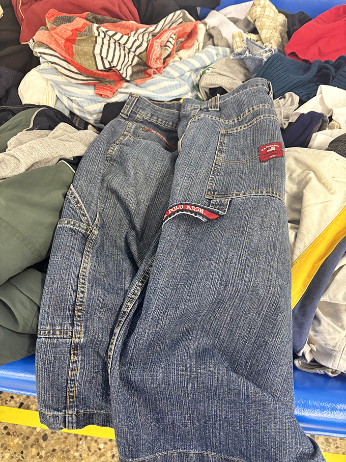 Treasure hunting at its finest! A pair of name-brand jeans peeks out from the textile jungle, waiting for someone with a keen eye to rescue them.