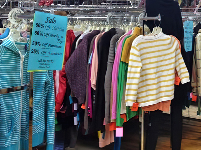 Rainbow racks of possibility! The sign promises 50% off, but the real value is finding that perfect striped top that looks brand new.