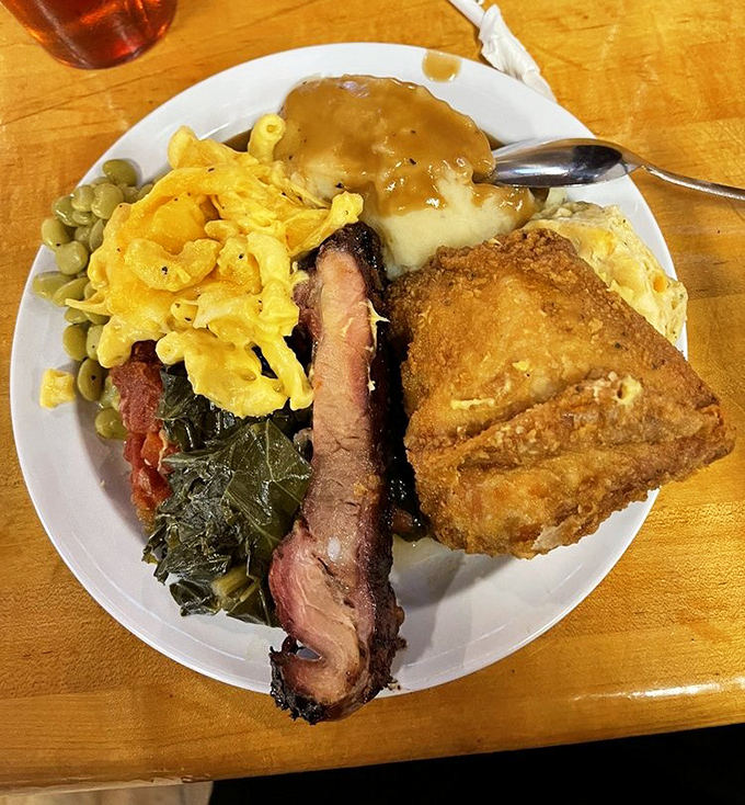 A plate that tells a story of smoke, spice, and everything nice&mdash;collards, mac and cheese, and fried chicken that makes you want to hug the cook.