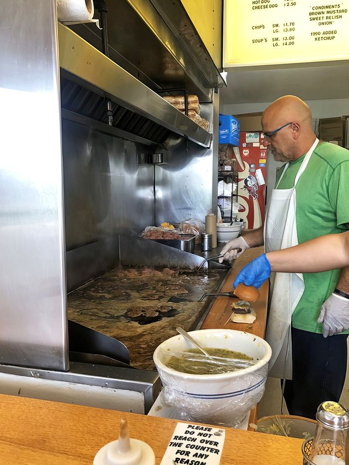 The maestro at work! Decades of burger-flipping expertise on display as each patty gets the attention a Michelin-starred chef gives foie gras.