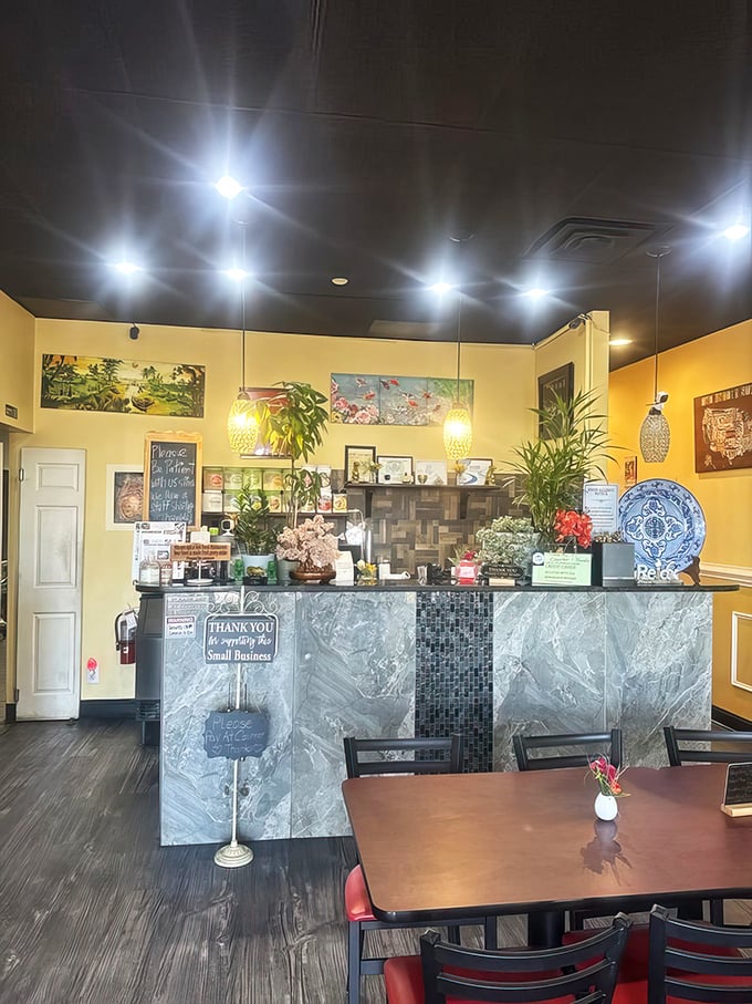 The counter area decorated with plants and artwork shows someone here actually cares about making the space feel warm and inviting.