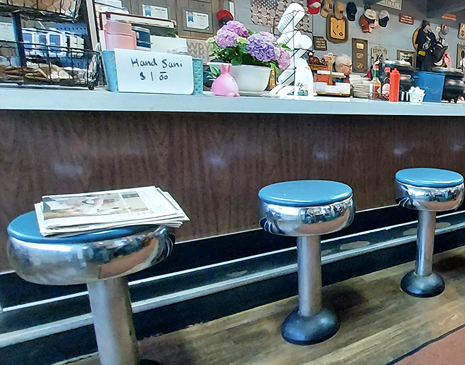 Classic diner counter seating where strangers become neighbors and the morning paper waits for thoughtful perusal between bites.