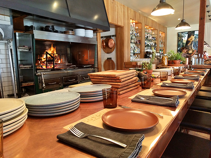 The counter offers front-row seats to culinary theater, where flames dance and chefs transform simple ingredients into edible art.