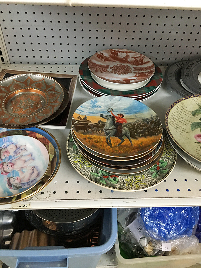 Decorative plates that once graced grandmothers' china cabinets now await new homes. That cowboy plate definitely belonged in someone's Western-themed dining room.
