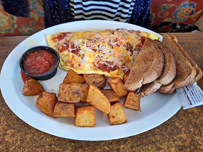 An omelet that's seen more fillings than a dentist's office, served with home fries and toast that complete breakfast's holy trinity.