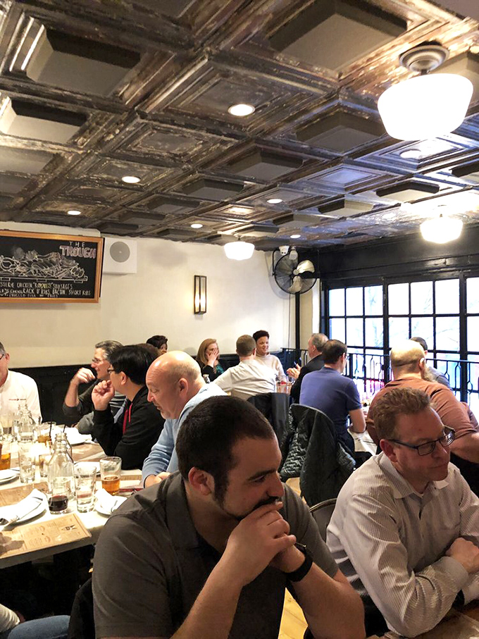 A packed house of food enthusiasts deep in that special trance that happens when conversation and exceptional food collide.. diners