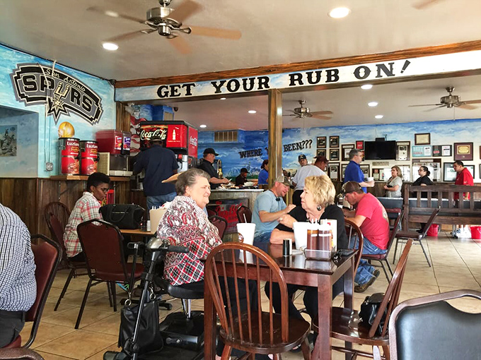 The "Get Your Rub On" sign isn't just decor&mdash;it's life advice. These diners aren't just eating; they're participating in a time-honored Texas ritual.