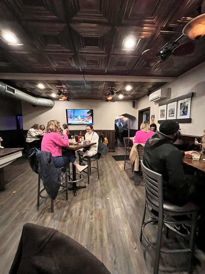 The ornate ceiling adds unexpected elegance to this casual space where friends gather to share stories and multiple wing baskets.