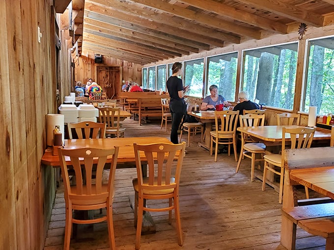 Wooden tables bathed in natural light create the perfect stage for the smoky drama about to unfold on your plate.