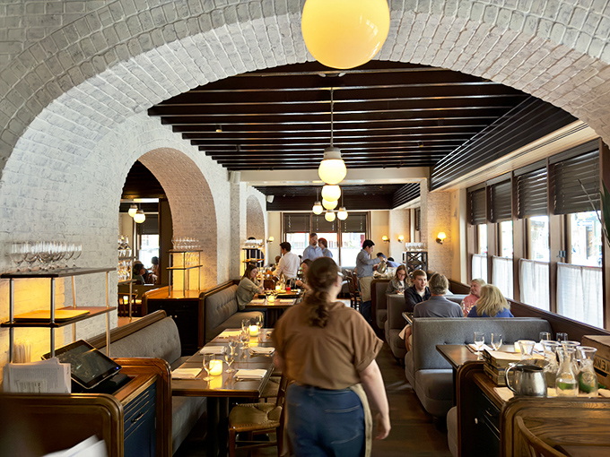 The white brick archways frame diners enjoying their meals like a Renaissance painting titled "People Having a Really Good Day."