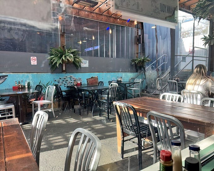 Sunlight streams through windows into a dining area where the ocean-inspired mural reminds you exactly why you're here.