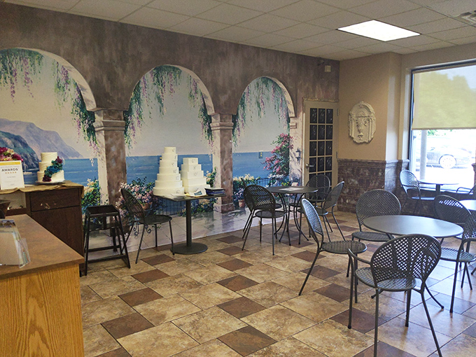 Mediterranean murals transport you to coastal vistas while you contemplate which cake deserves your attention. Vacation vibes included free.