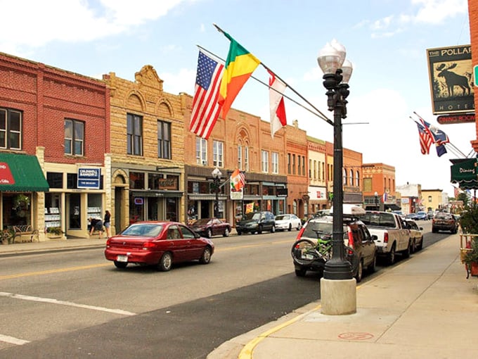 International flags wave hello above Broadway's historic buildings. Small town, world-class welcome.