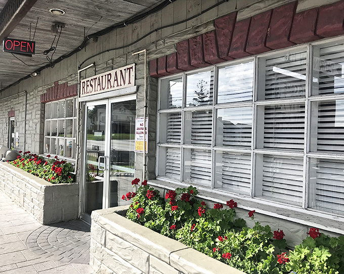 Red geraniums welcome visitors at the entrance&mdash;a touch of color that says "homemade" before you even step inside.Red geraniums welcome visitors at the entrance&mdash;a touch of color that says "homemade" before you even step inside.