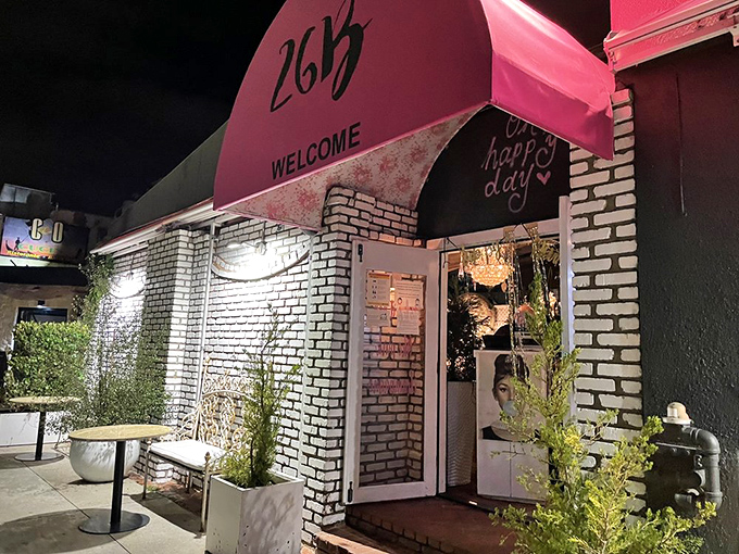 Black and white bricks meet potted palms in this outdoor seating area. A perfect spot to people-watch while debating whether to order seconds.