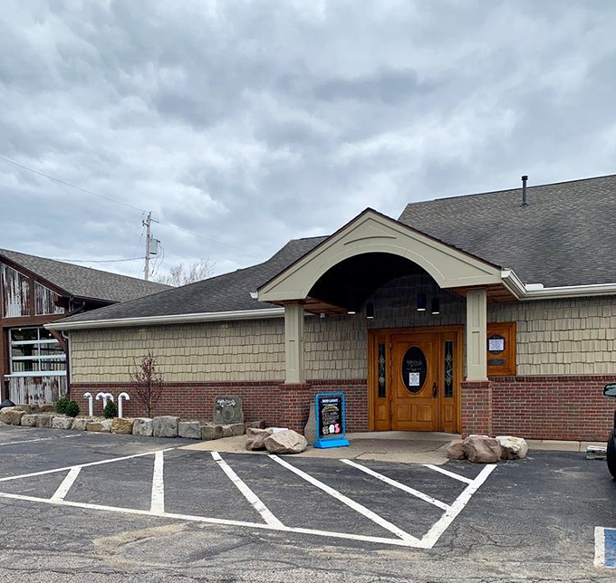 Another entrance view showcases the restaurant's thoughtful design with natural stone elements and wooden doors that say "come in, get comfortable."