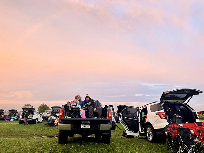 Sunset paints the sky as moviegoers transform their vehicles into cozy nests of blankets and anticipation.