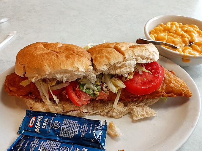 A sandwich symphony on a plate &ndash; crispy fish nestled in a pillowy roll with fresh tomatoes and crisp lettuce, while mac and cheese stands by as the perfect supporting act.