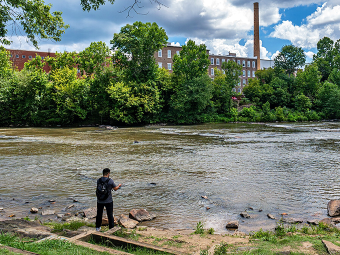 The Haw River provides a peaceful backdrop for fishing enthusiasts, where the industrial past meets natural beauty in a scene straight from Norman Rockwell.