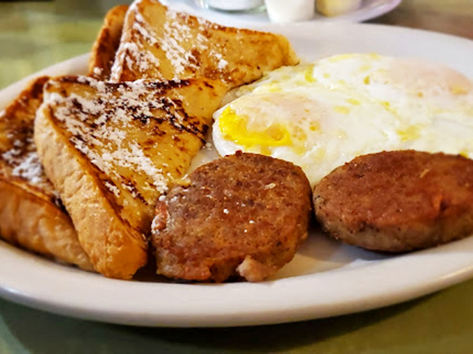 French toast dusted with powdered sugar alongside sausage and eggs&mdash;the breakfast trinity that converts even the most devoted lunch enthusiasts.
