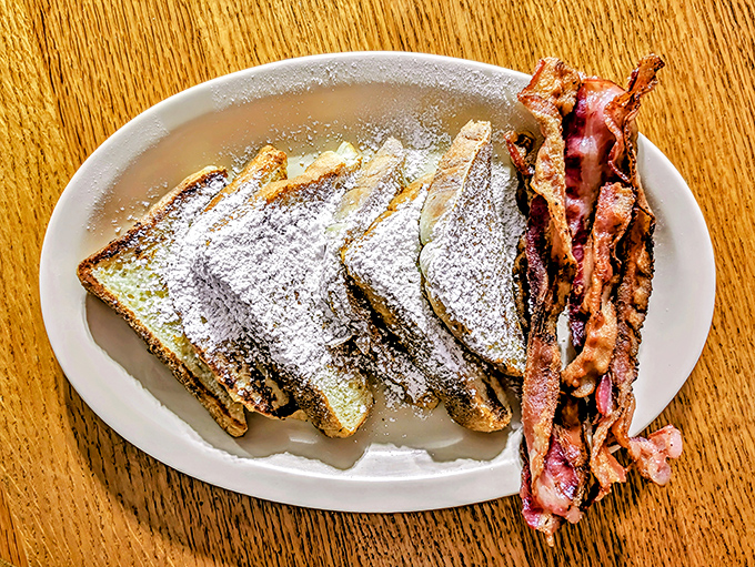 French toast dusted with powdered sugar like the first snow of winter, with bacon standing by for the perfect sweet-savory balance.