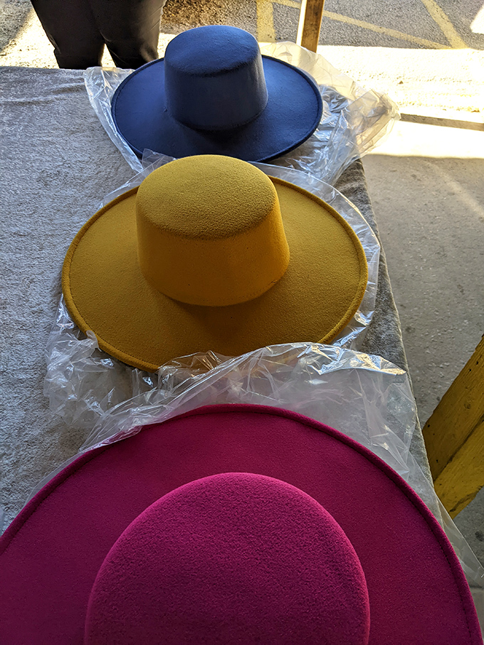 Wide-brimmed statement hats in bold yellow, navy and fuchsia await their moment to shine at summer weddings or derby days.