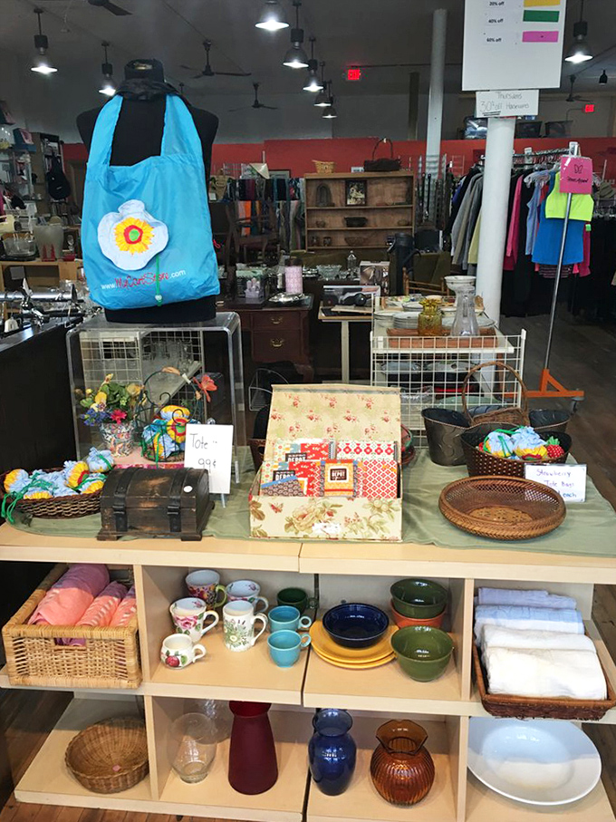 A thrifter's still life: ceramic mugs, woven baskets, and colorful dishware arranged with the care of a museum curator.
