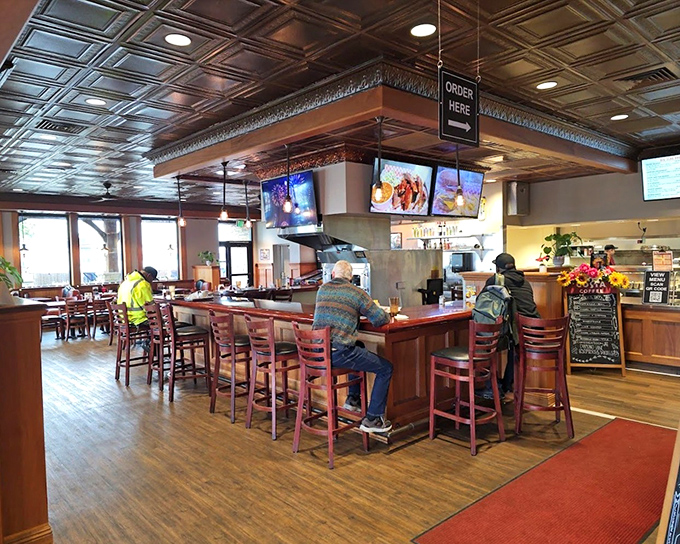 Morning light streams through windows illuminating a diner where strangers become friends over coffee refills.