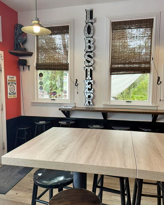 Between the vertical "LOBSTER" sign and warm wooden tables, this corner feels like the VIP section of seafood heaven. No velvet rope required.