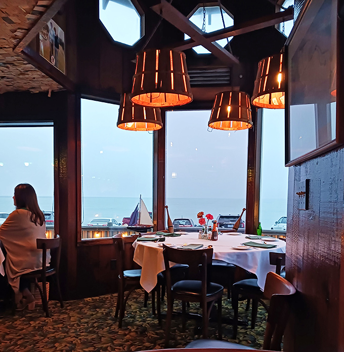 The dining room's barrel-shaped pendant lights cast a warm glow over white tablecloths, creating an atmosphere that's both nautical and nice.