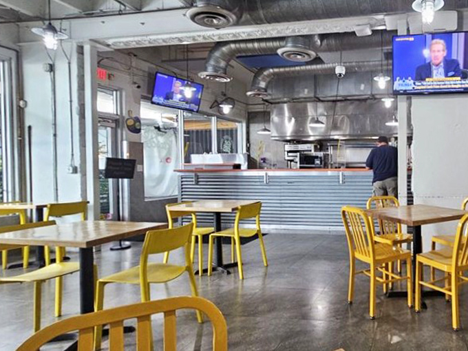 Yellow chairs brighten the industrial-chic space where seafood dreams come true. The kitchen counter view is Miami's version of theater-in-the-round.