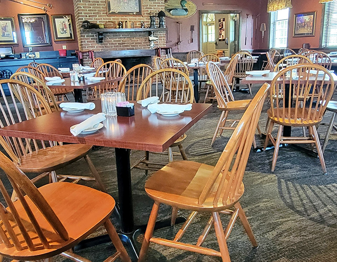 A dining room that balances historic charm with modern comfort. The brick fireplace stands ready to warm both the room and your soul.