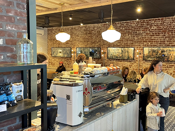 Vintage pendant lights casting a golden glow over espresso machines and pastries. This isn't just a caf&eacute; &ndash; it's theater where coffee plays the leading role.